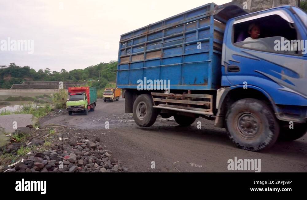 TRUCK AND MOTORCYCLE CROSSING SANDY ROAD TO PICK UP SAND ON THE SAND ...