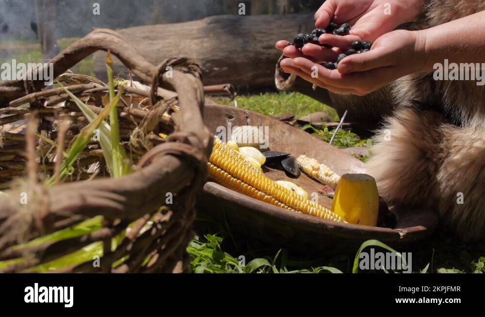 Native American Women using primitive tools to prepare food over an ...