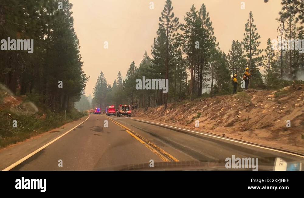 Driving past firetrucks and firefighters calming the forest fires in ...