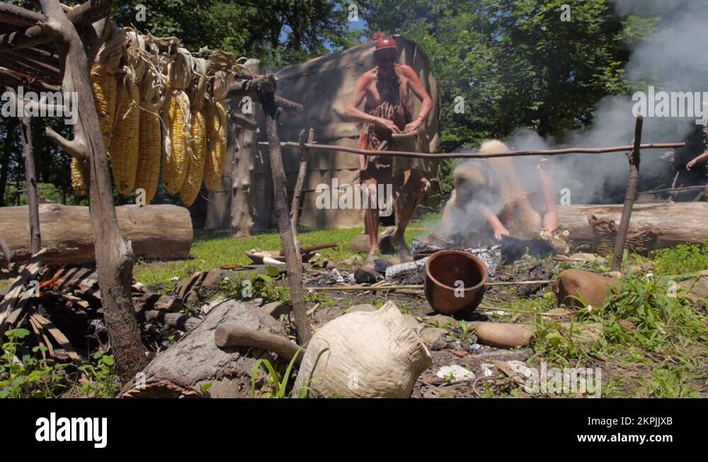 Native American Family using primitive tools to prepare food over an ...