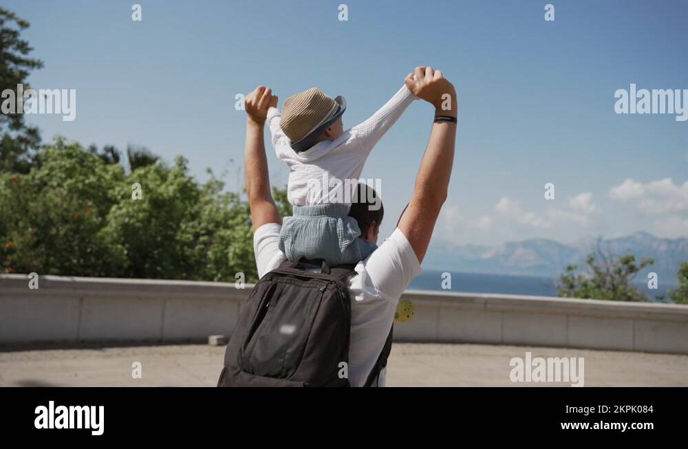 Father with son on shoulders walks on observation deck Stock Video ...