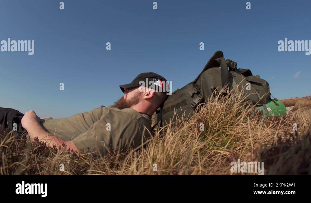 A man sleeping in grass wearing a black country flag cap Stock Video ...
