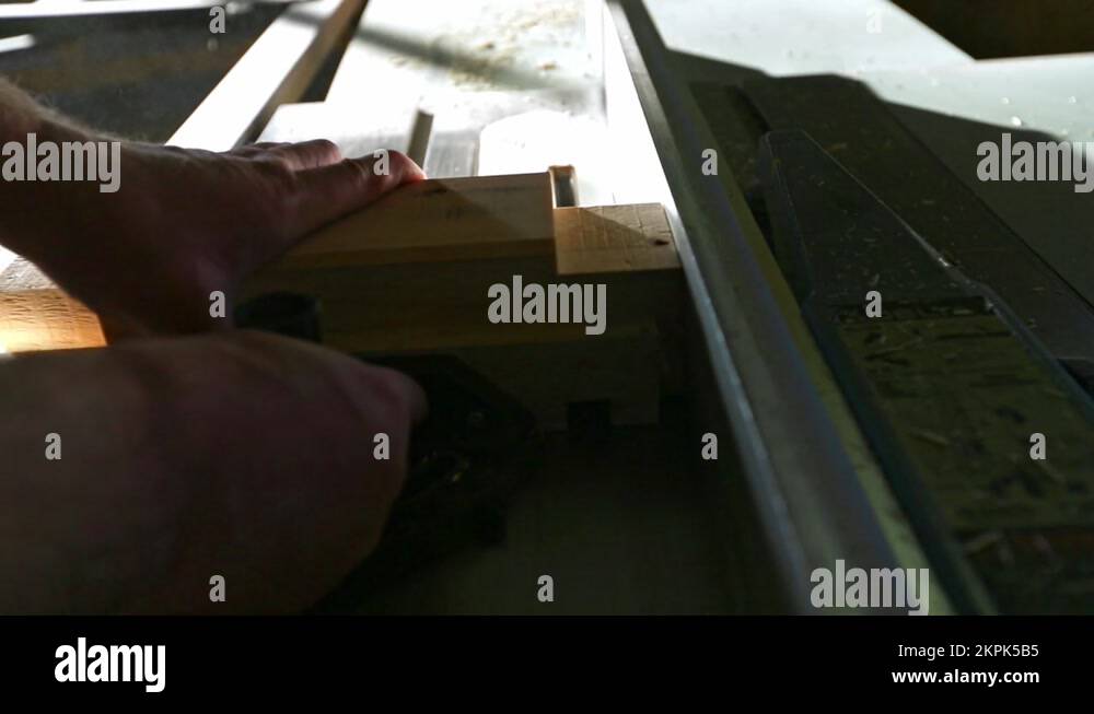 A woodworker places a piece of wood on a table saw with a stacked dado ...