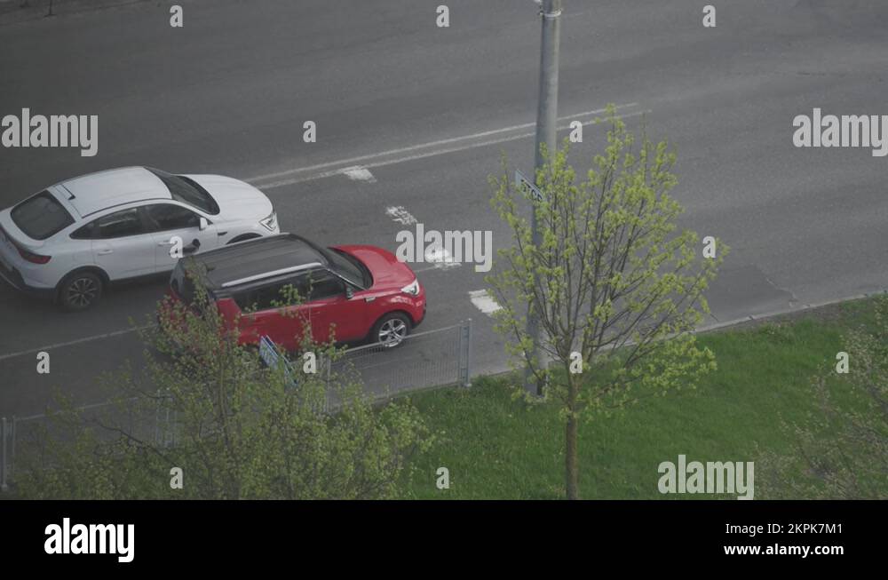 Two cars start moving from erased white stop line in city, top view ...