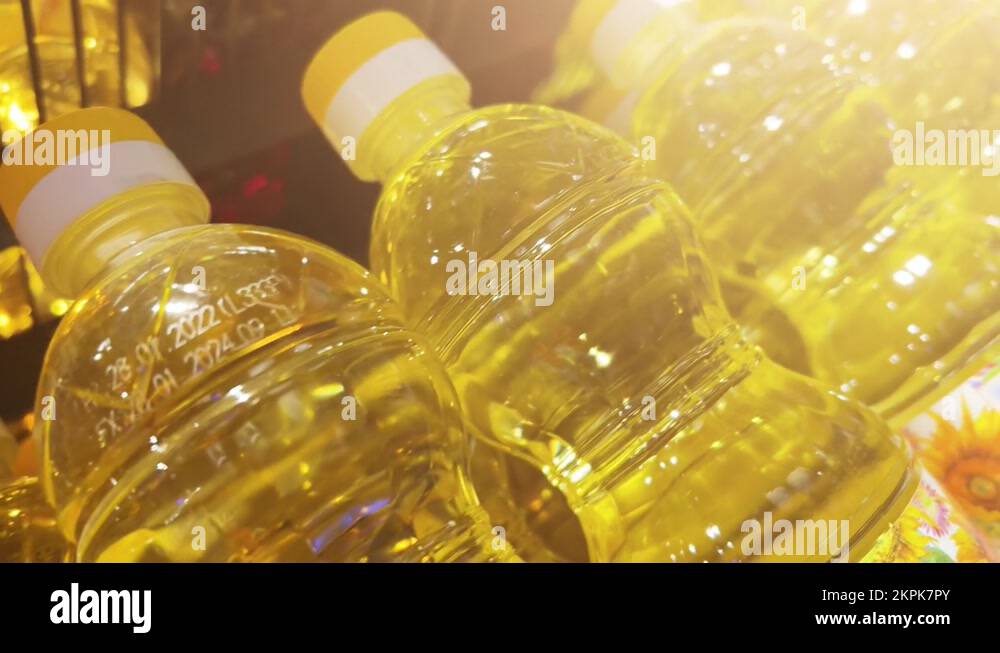 Sunflower or corn oil in plastic bottles line up on the shelf in a ...