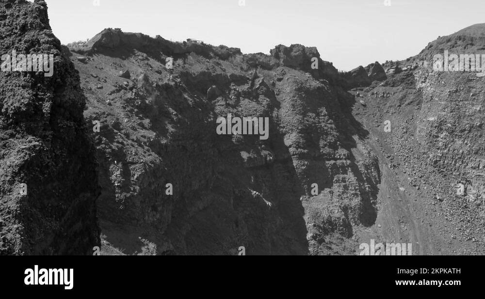Panning along the huge crater of the Mount Vesuvius volcano in black ...