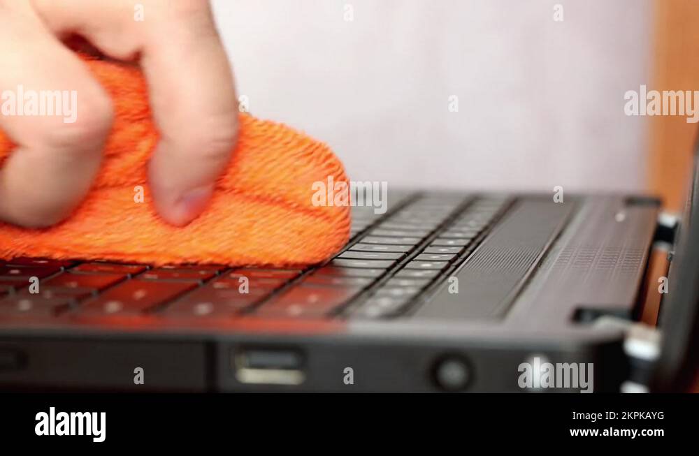 Male hand cleaning and sanitizing keyboard of laptop from dust and ...