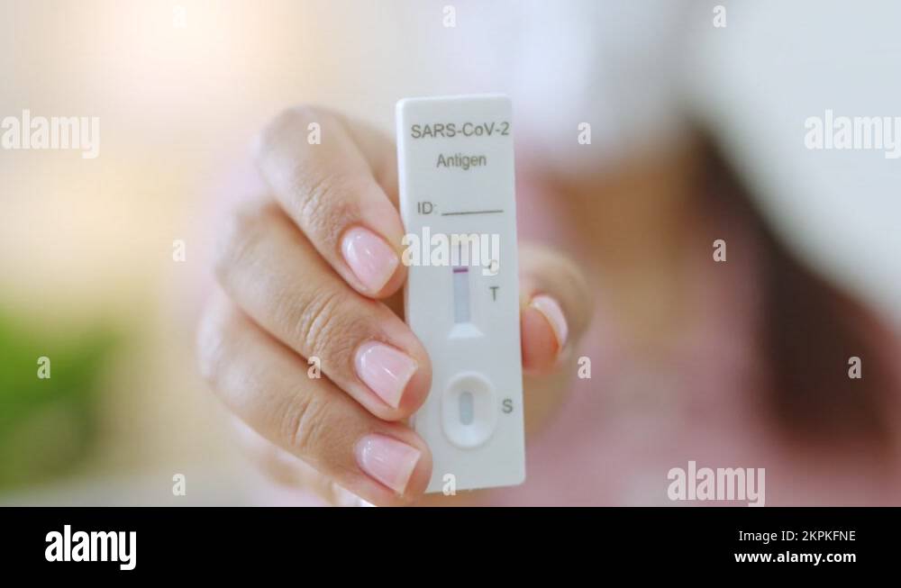Young Asian woman using rapid antigen test kit (ATK) for self test at ...