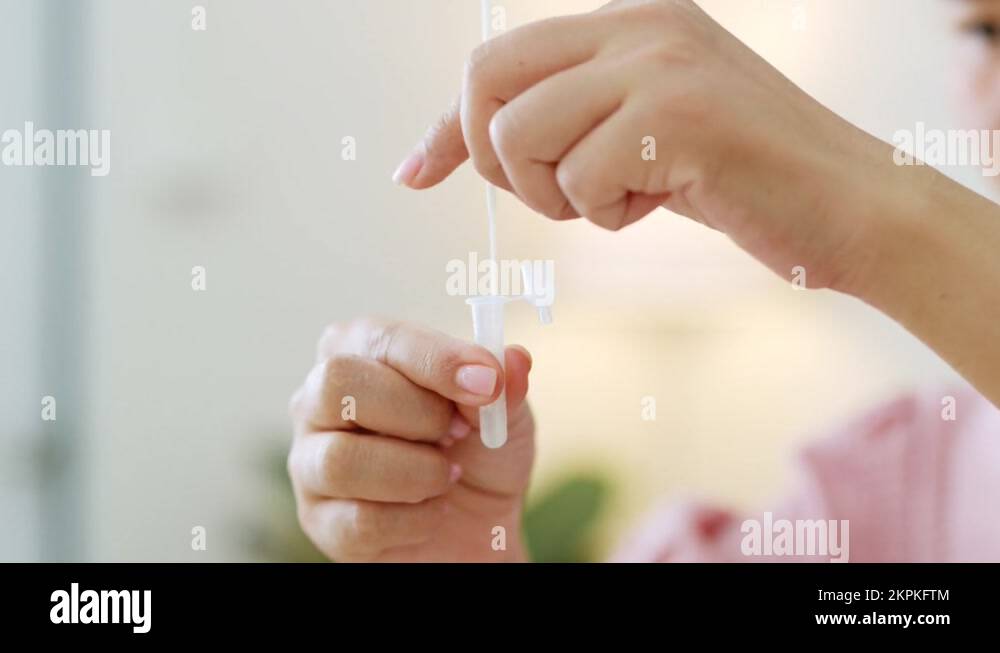 Close up hand using rapid antigen test kit (ATK) for self test at home ...