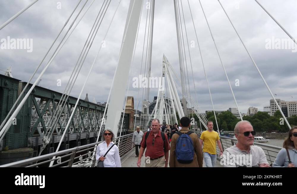 People walking along Golden Jubilee Bridge Editorial use only Stock ...