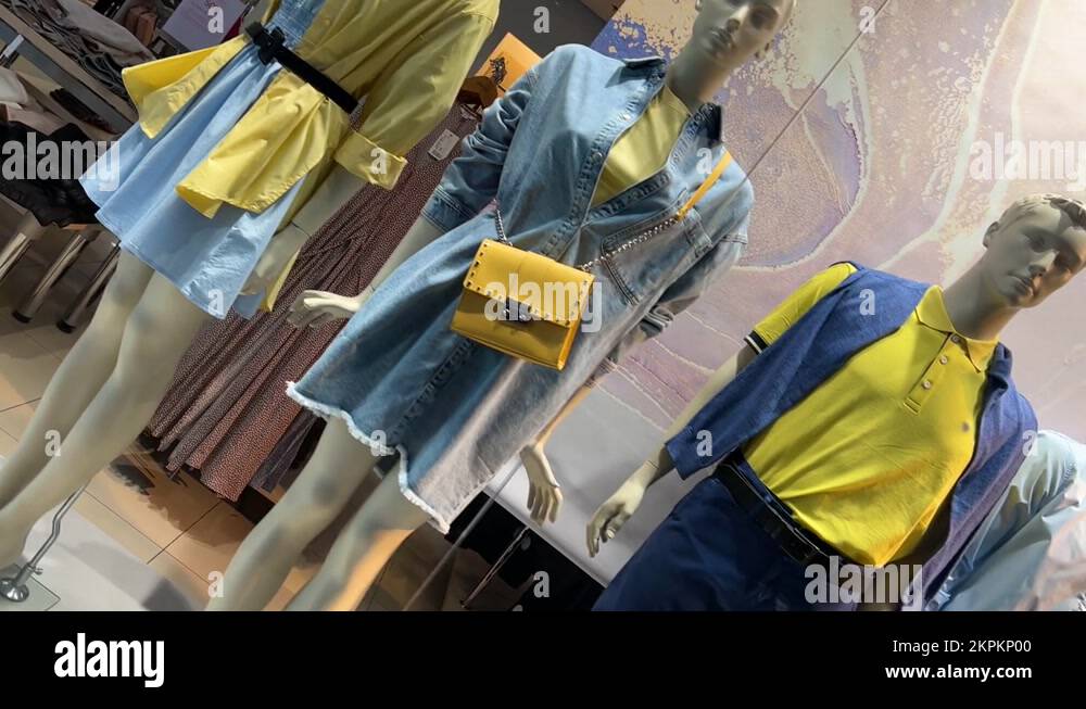 Female and male mannequins stand in the window of a clothing store or ...