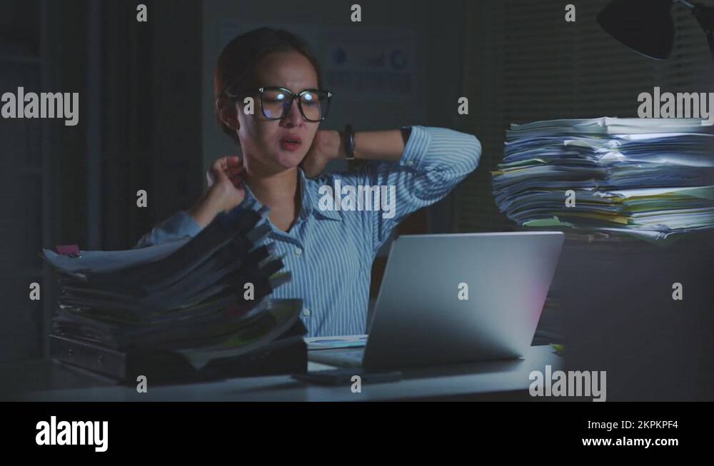 Tired Asian employee stretching oneself fatigued from working, office ...