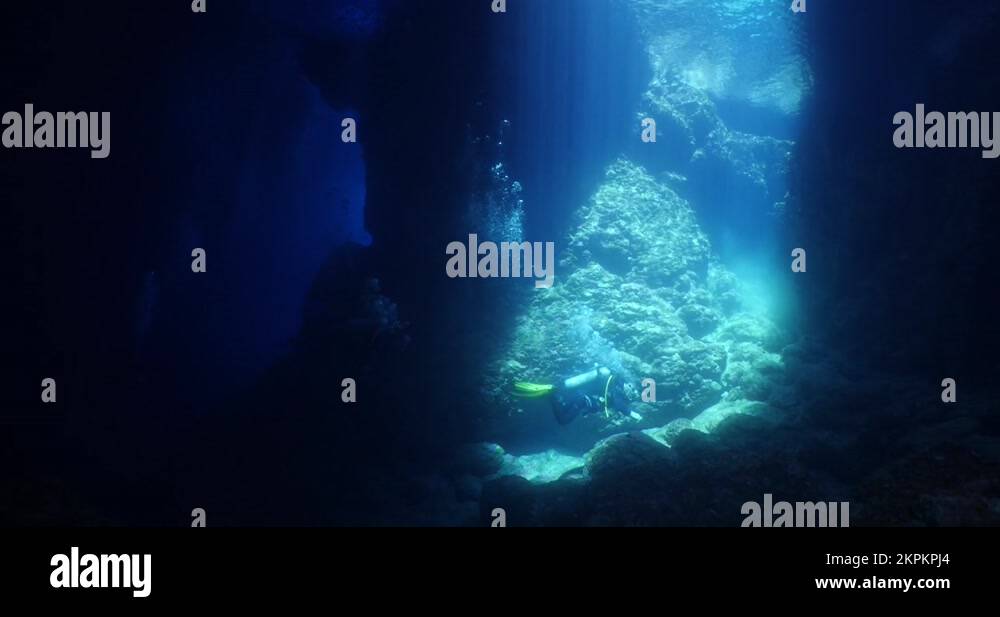 sun light rays beams underwater cave scuba divers to see ocean scenery ...
