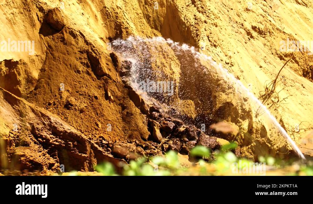 Spraying water on dune to rinse sand causing erosion, close up Stock ...