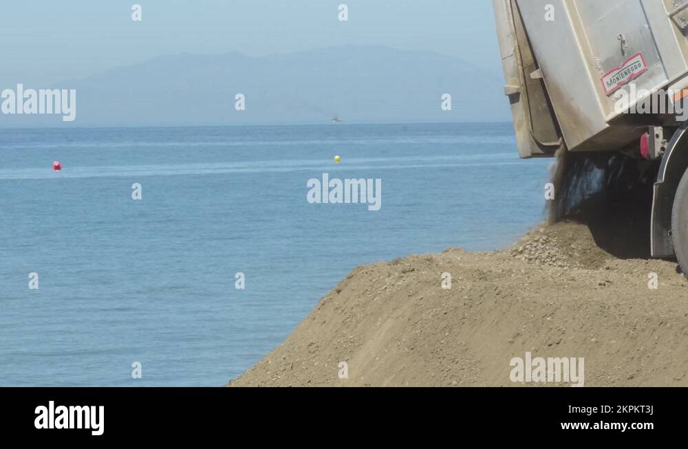 Truck unloading sand together a beach. Beaches generations works Stock ...