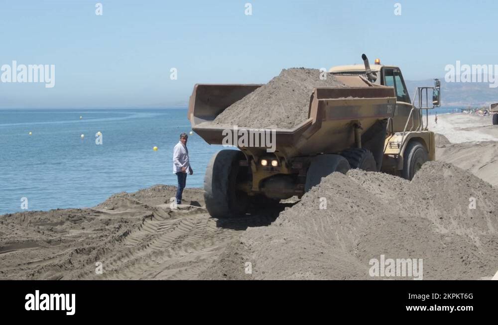 Truck unloading sand together a beach in works of generation of beaches ...