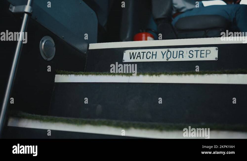 Closeup schoolbus entrance stairs with plate. Sign warn to watch your ...
