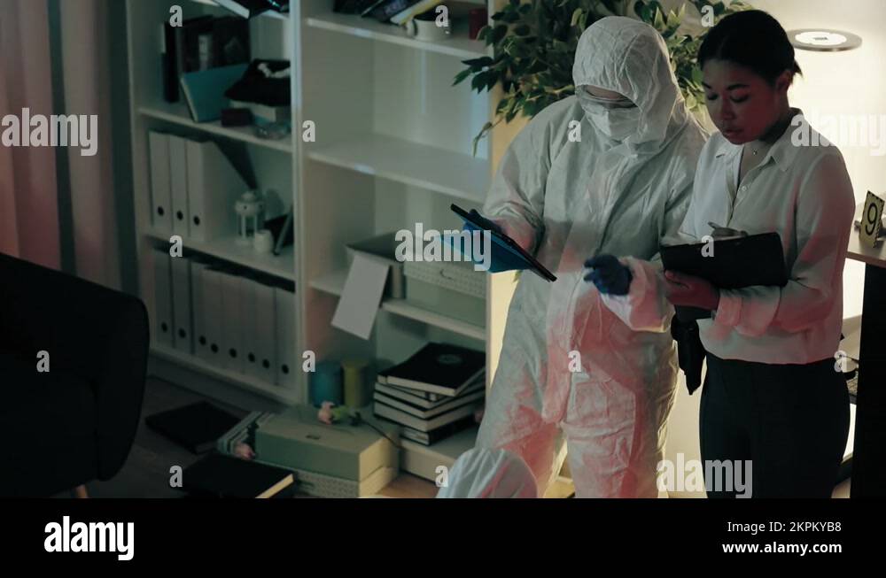 Team of police investigators working at crime scene, documenting ...