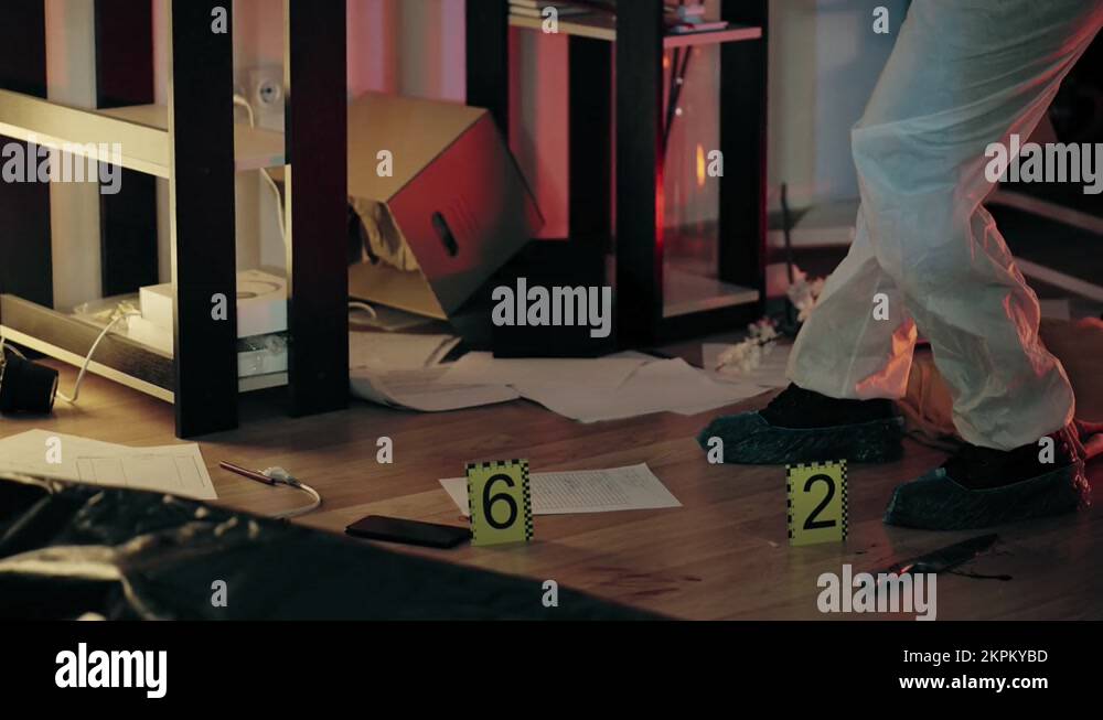 Forensic expert in protective gear collecting crime evidence at murder ...