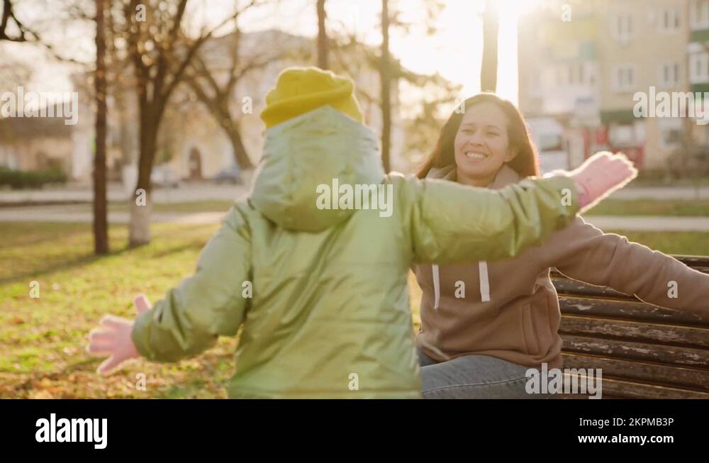 little child hugs his beloved mother sun. happy family park sunset ...