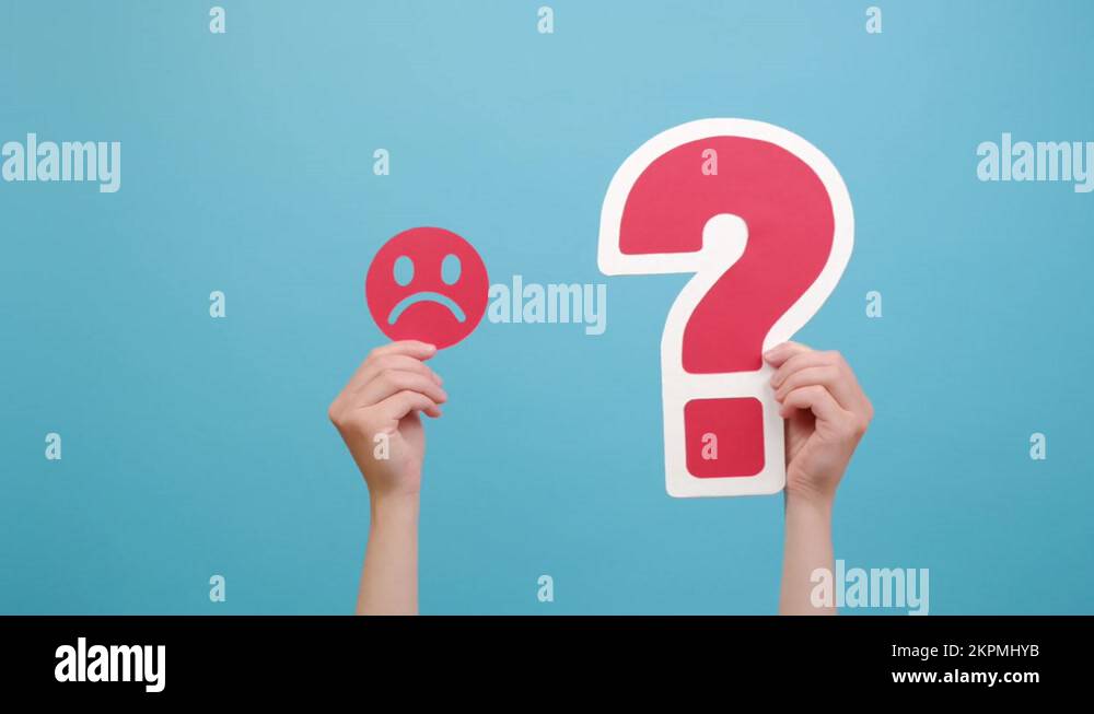 Female hand holding red unsatisfied face emoticon and question mark ...