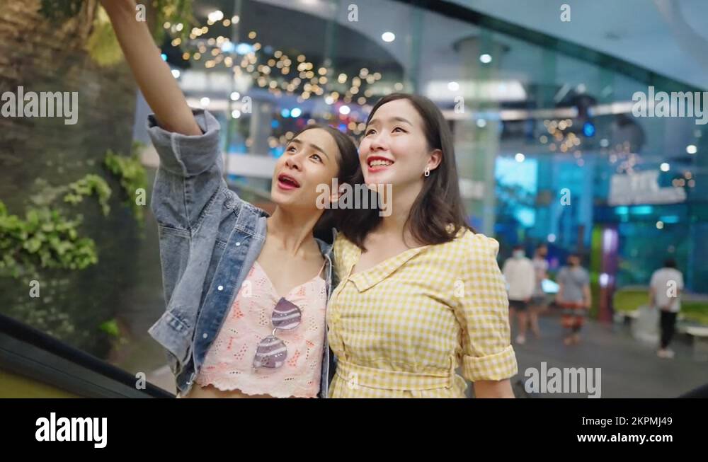 Two young asian female friends hanging out together inside shopping ...