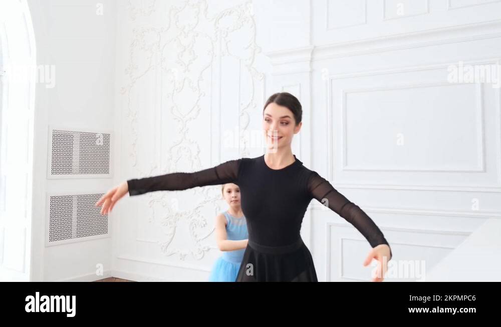 Young girls from ballet dancing ballet in white studio. Pretty graceful ...