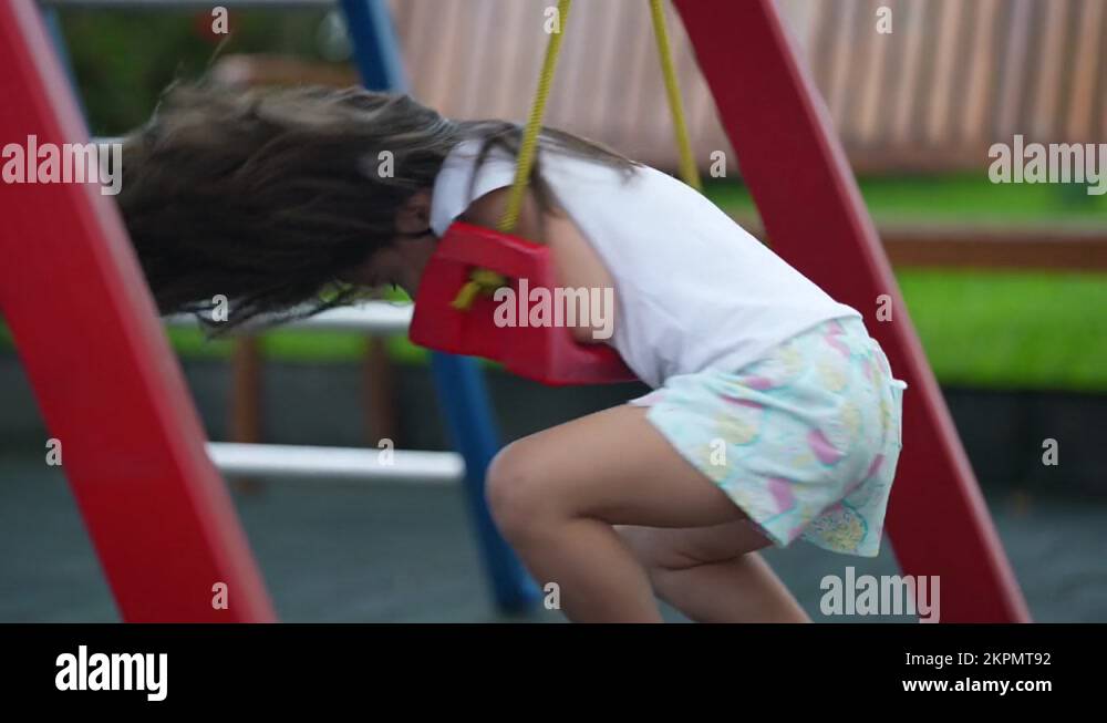 Child turning at playground swing one little girl twisting at park ...