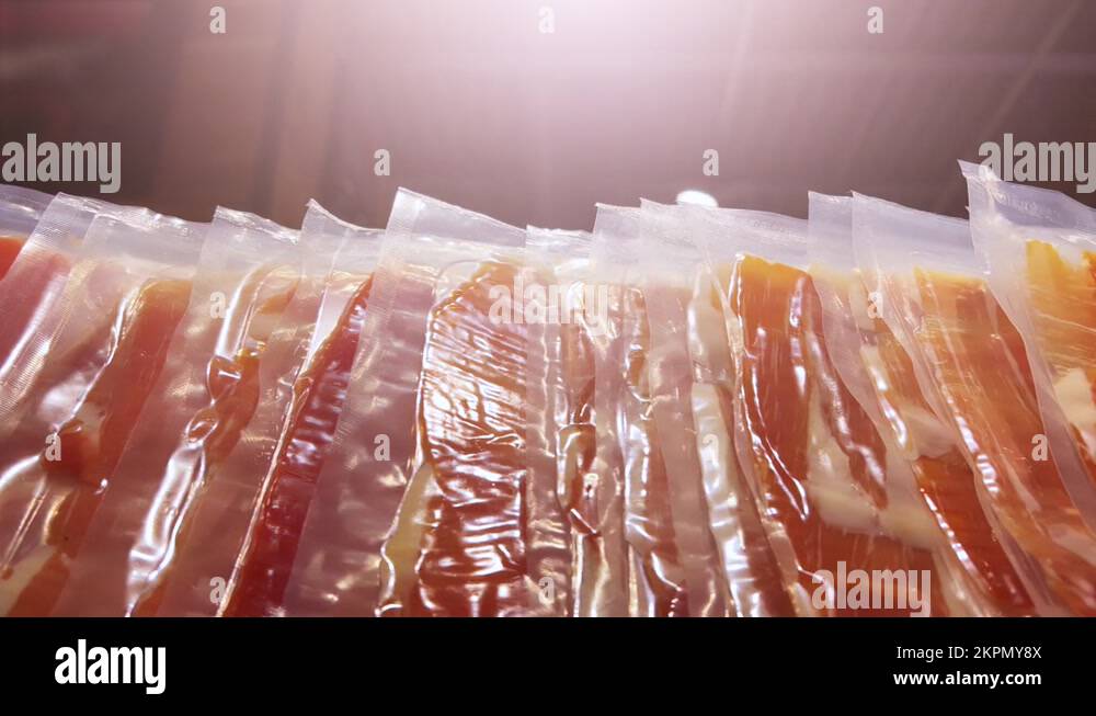 Iberian ham in vacuum plastic packs on a supermarket or grocery window ...