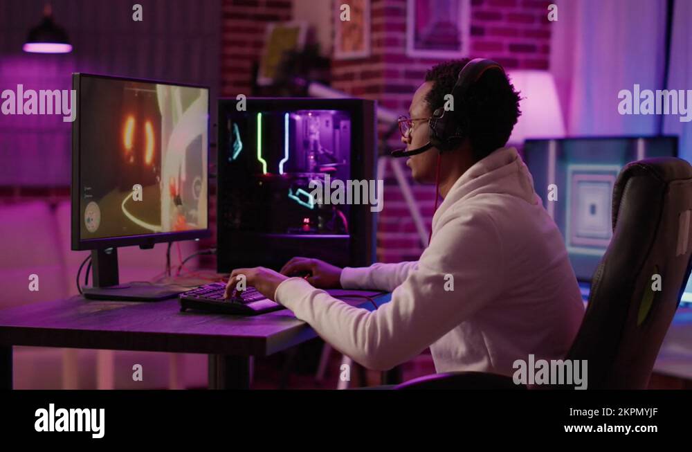 African american gamer relaxing playing online action game using pc ...