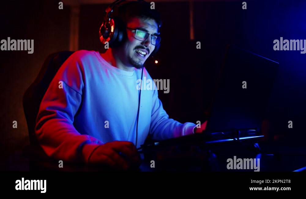 Man angrily shouts into laptop screen playing videogames, front view ...