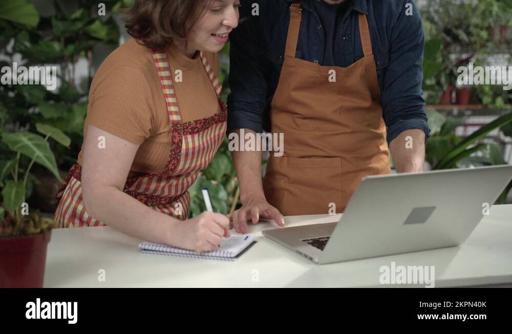 Employees checking laptop inventory at small local business store. Male ...