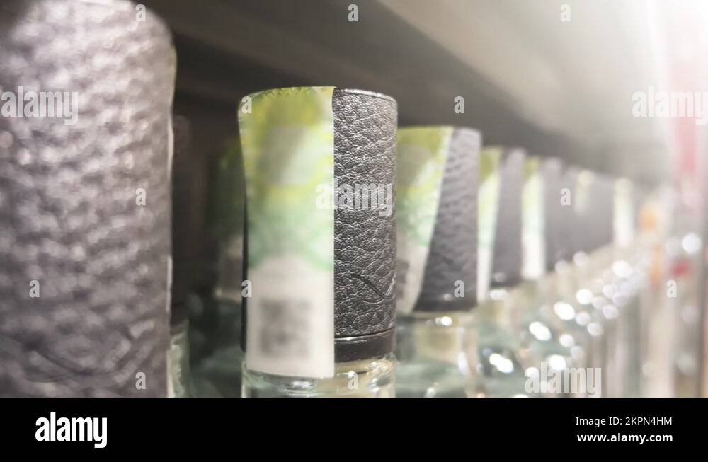 Dry gin bottles line up on the shelves of a liquor store or ABC store ...