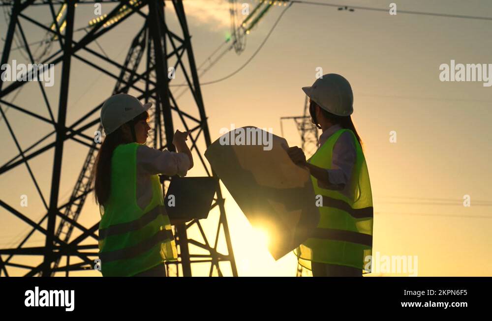 Two construction engineers work together on an electrical transmission ...