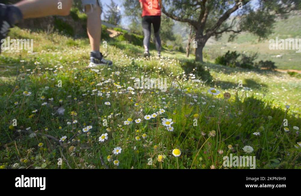 Close up of footsteps of young boy and girl taking a run in lush green ...