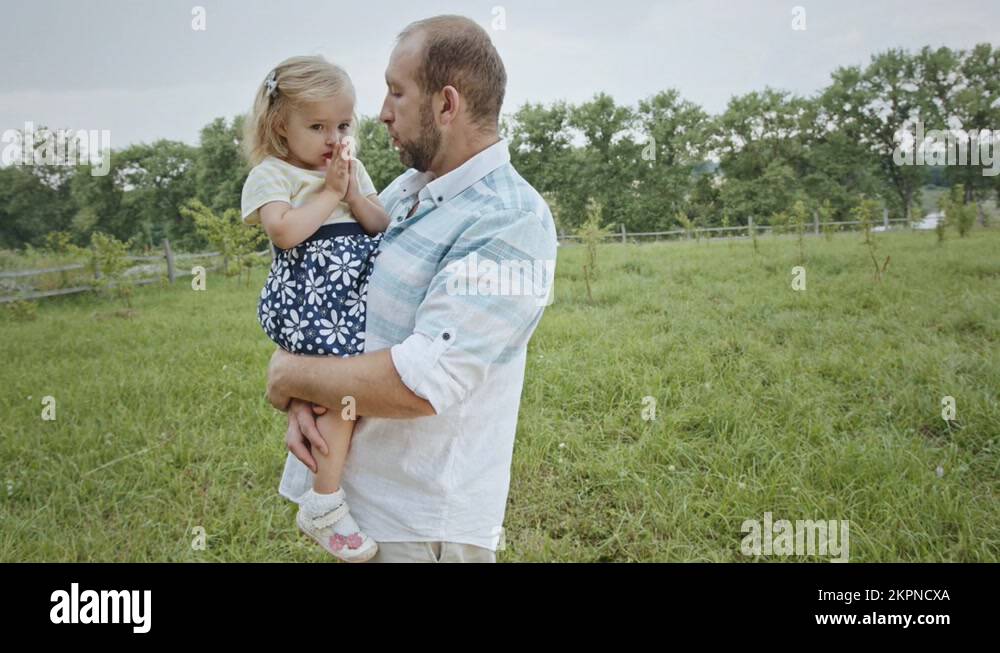 Father kissing daughter in field. Adult dad in casual clothes talking ...