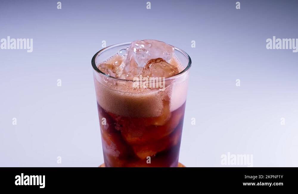 Coca Cola is poured into a glass from a bottle. White background Stock ...