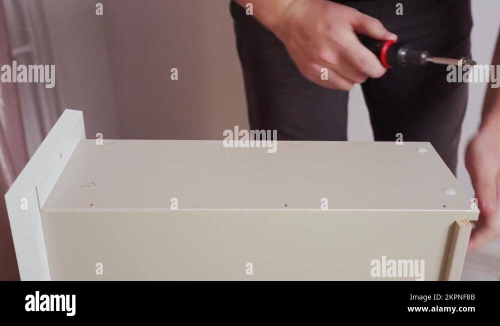 men's hands with a screwdriver twist the screws, assembling the shelf ...