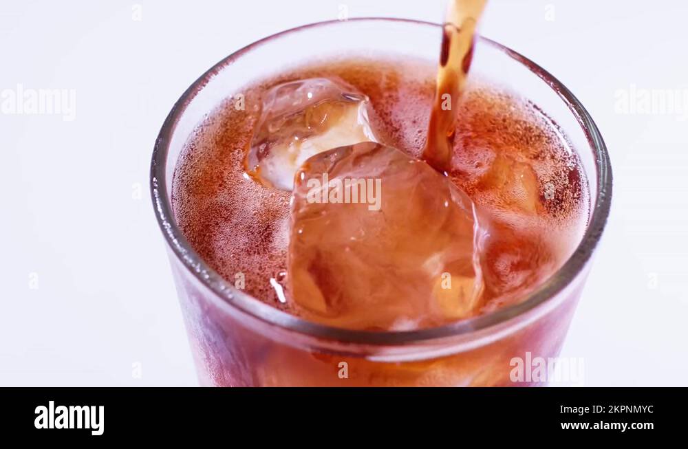 Coca Cola is poured into a glass from a bottle. White background Stock ...