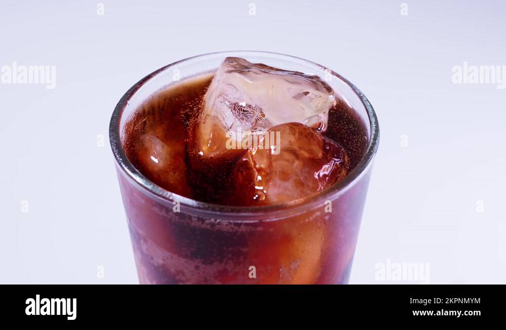 Coca Cola is poured into a glass from a bottle. White background Stock ...