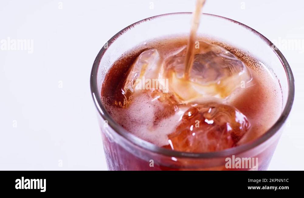 Coca Cola is poured into a glass from a bottle. White background Stock ...