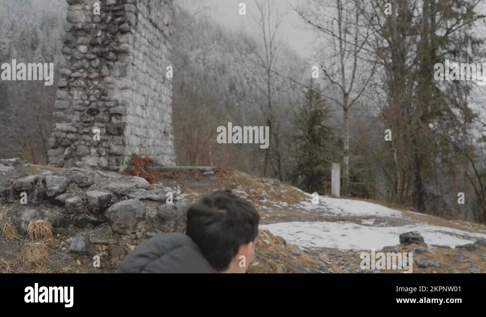 Young man jumping and running at a medival ruin and slipping on a ...