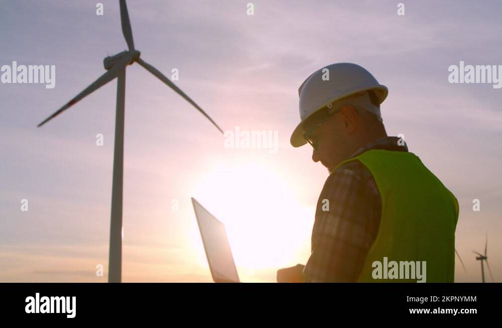 Windmill engineer watching wind turbines in operation on a laptop Stock ...