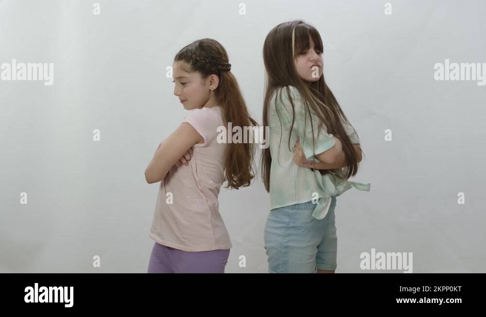 Two little girls are fighting with each other on a white background ...