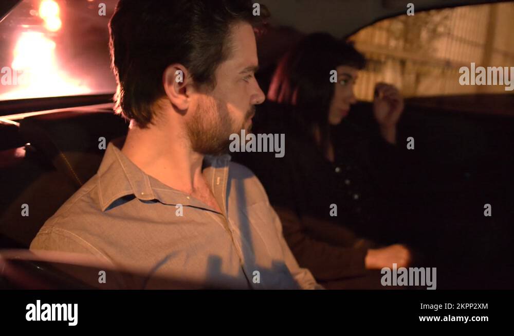 People inside car backseat at night. Man and woman riding taxi cab ...