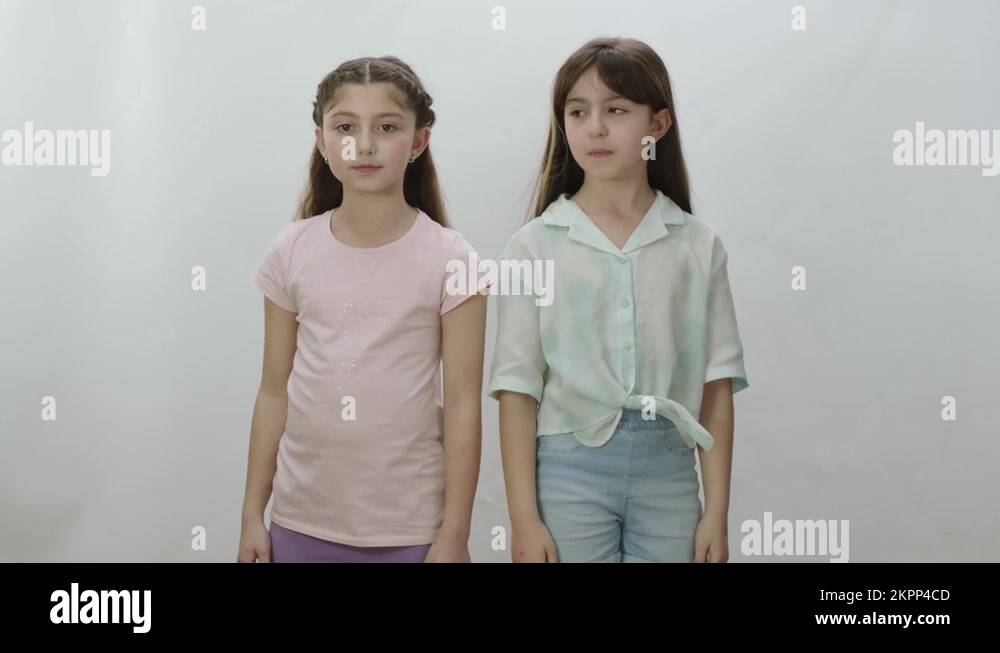 Two girls stand side by side isolated on white background Stock Video ...