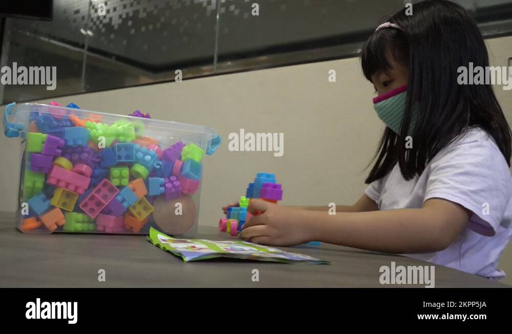 Chinese little girl with face mask play lego block Stock Video Footage ...