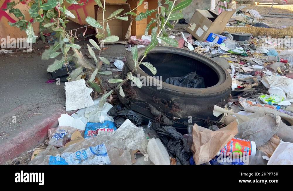 Pile of Trash Wrappers Lying on City Sidewalk Around Tire and Fast Food ...