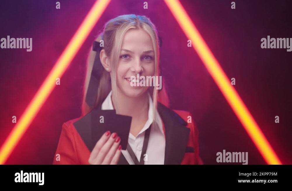 Cute smiling blonde school girl anime cosplay hold poker cards and show ...