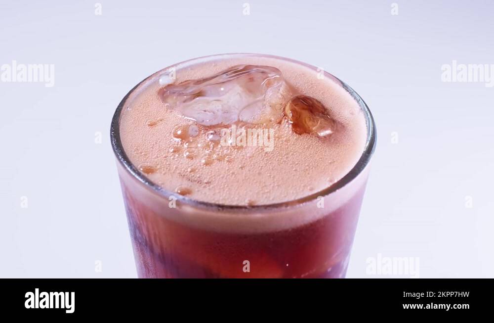 Coca Cola is poured into a glass from a bottle. White background Stock ...
